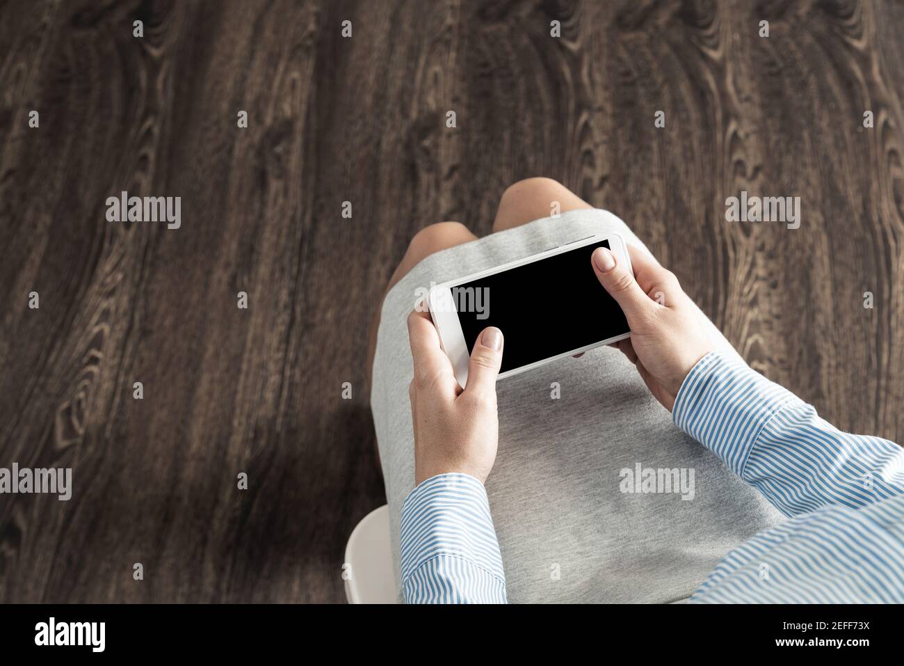 business woman with cell phone on her lap Stock Photo - Alamy
