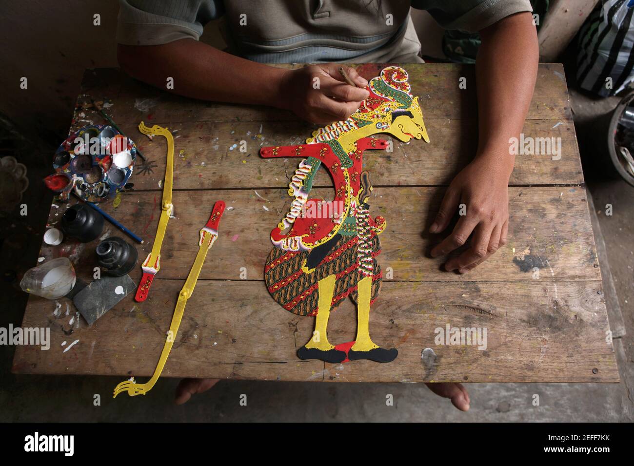 Craftsman colours a wayang kulit puppet in the Classic Wayang crafts ...