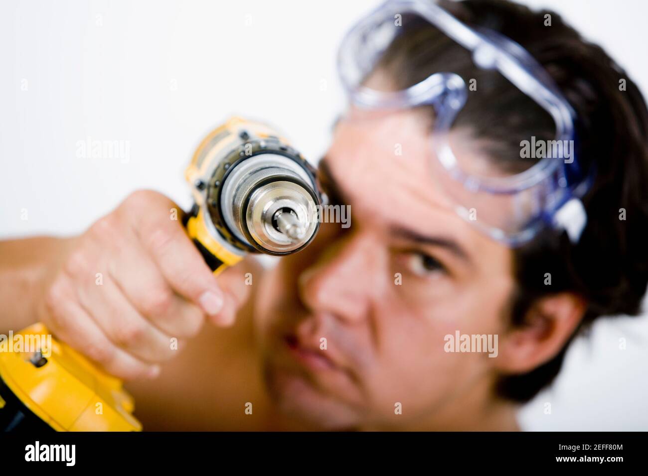 Portrait of a mid adult man holding a drill machine Stock Photo - Alamy