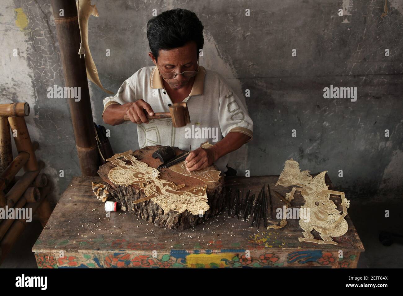 Craftsman makes a leather puppet for wayang kulit theatre in the ...