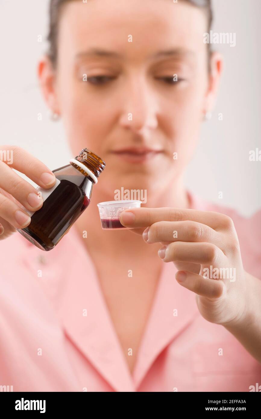 Female nurse pouring syrup into a bottle cap Stock Photo - Alamy