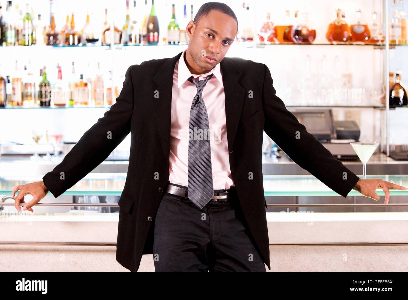 Portrait of a businessman leaning against a bar counter Stock Photo - Alamy