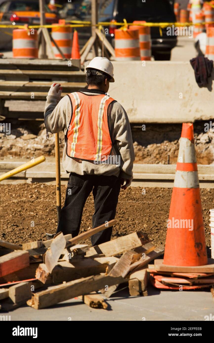 Rear view of a construction worker working at a construction site Stock ...