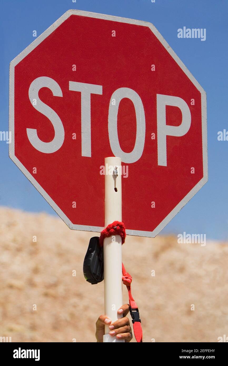 Close-up of a human hand holding a stop sign Stock Photo - Alamy
