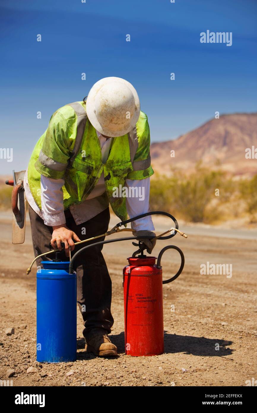Construction worker holding two cylinders Stock Photo - Alamy