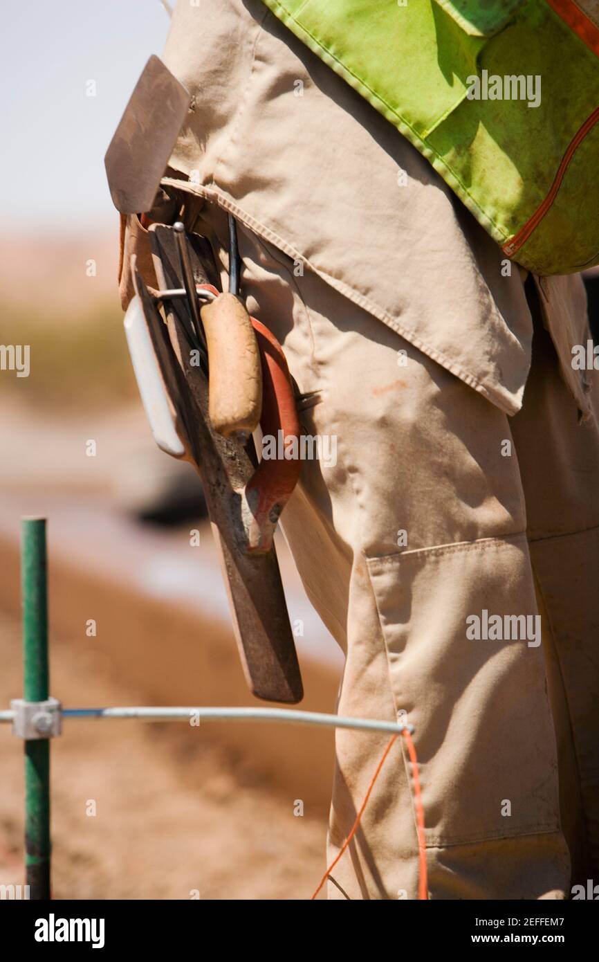 Mid section view of a construction worker carrying hand tools Stock ...