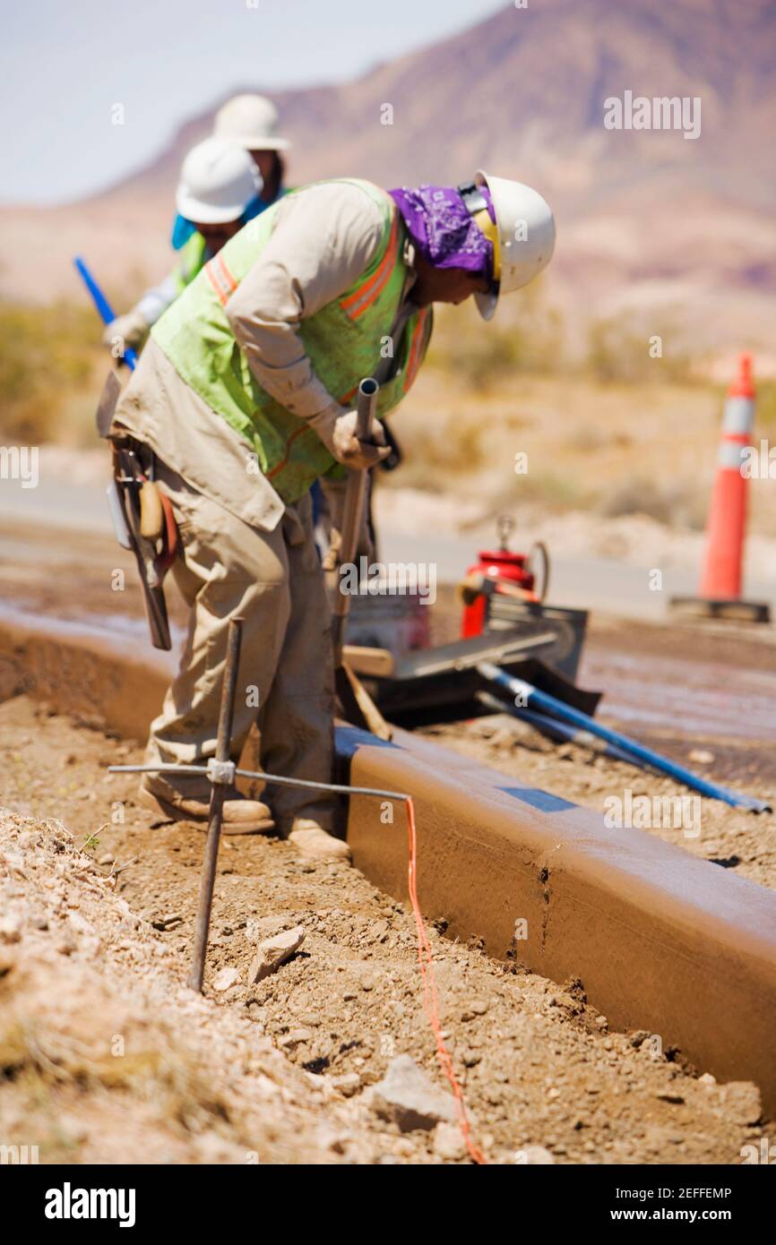 Three construction workers working at a construction site Stock Photo ...