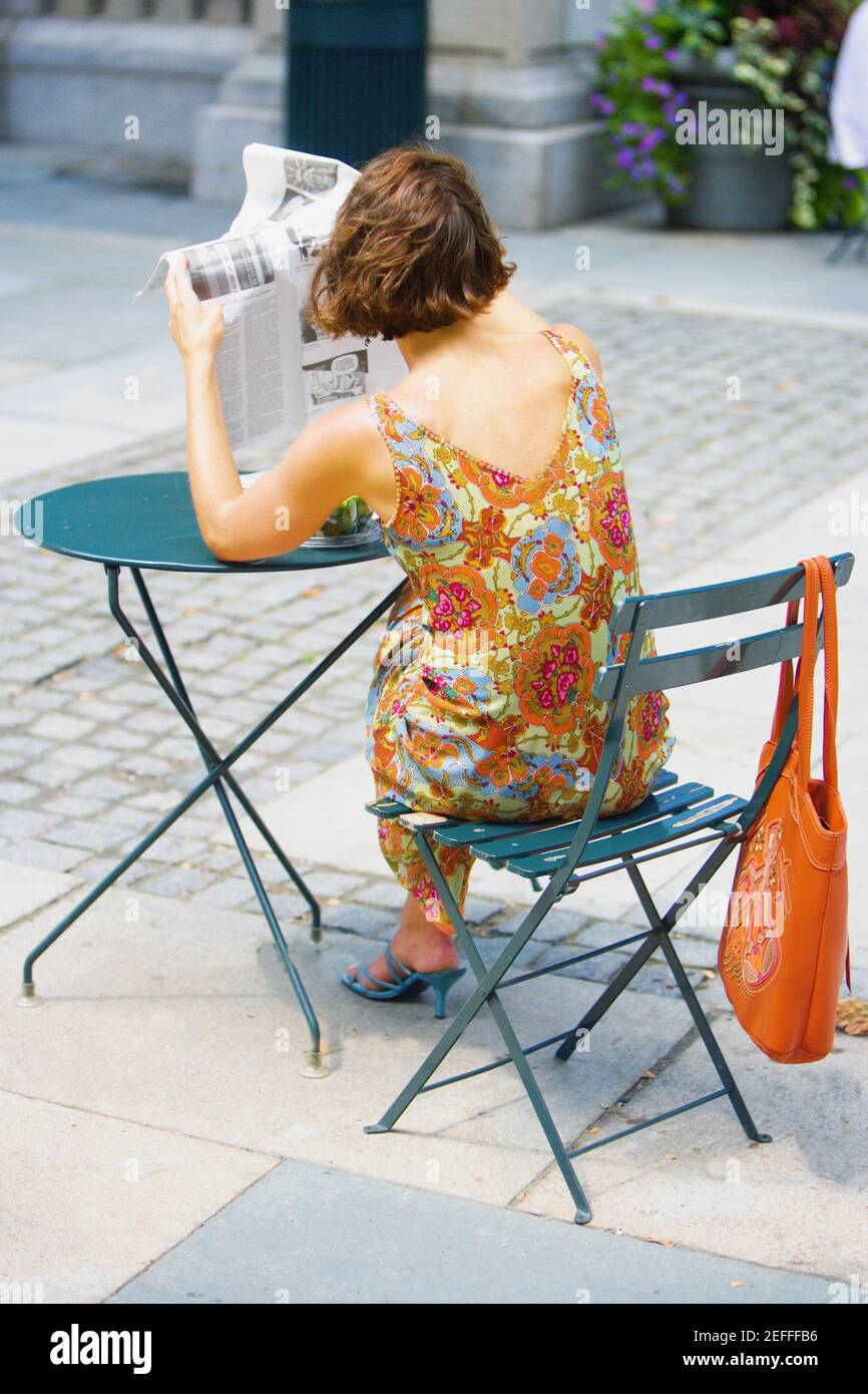 Rear view of a woman reading a newspaper Stock Photo - Alamy