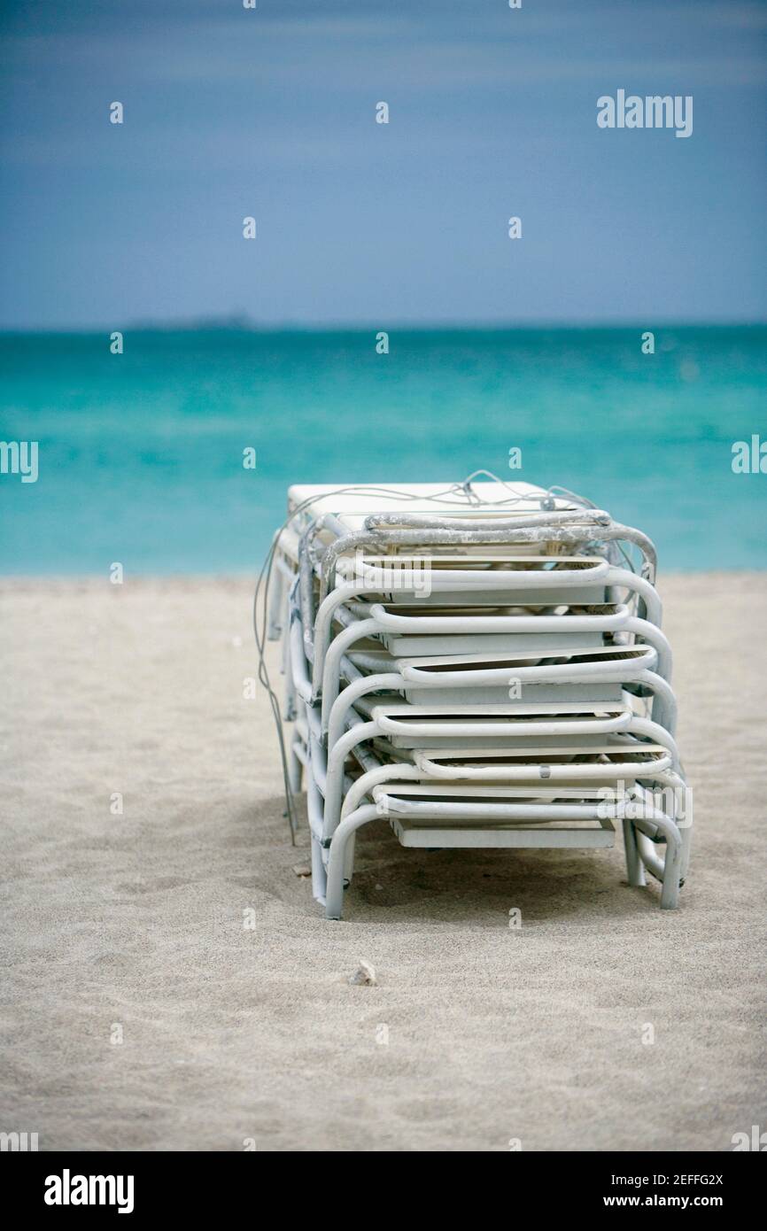 Stack of lounge chairs on the beach Stock Photo - Alamy