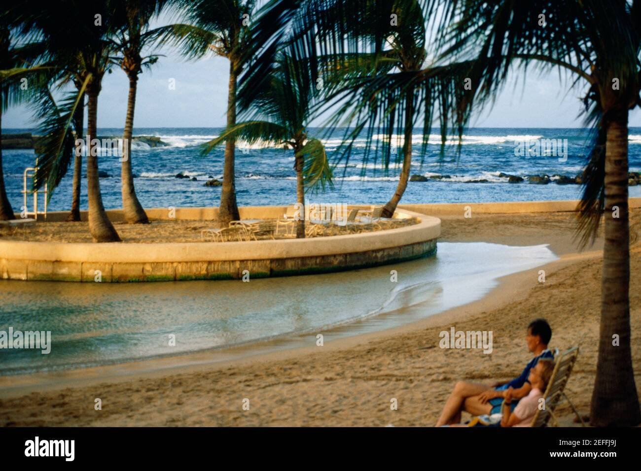 A couple is seen relaxing on a beach, Caribe Hilton, Puerto Rico Stock ...