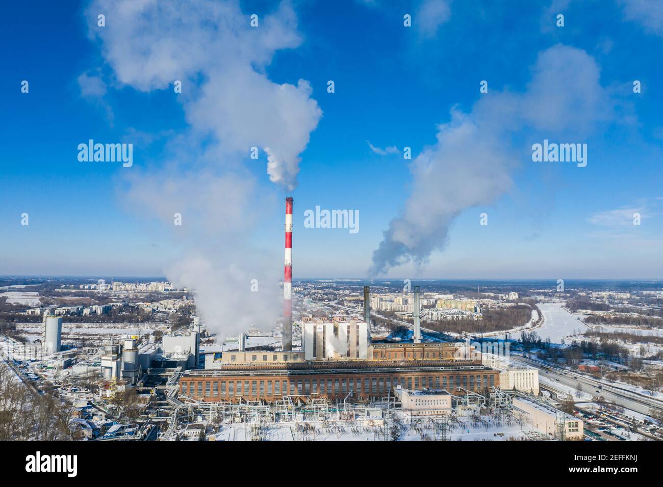 Power plant emitting smoke to the atmosphere against blue sky aerial ...