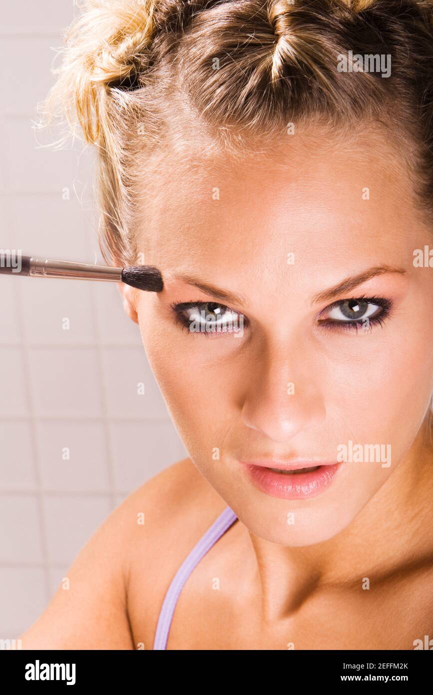 Portrait of a young woman applying eyeshadow Stock Photo - Alamy