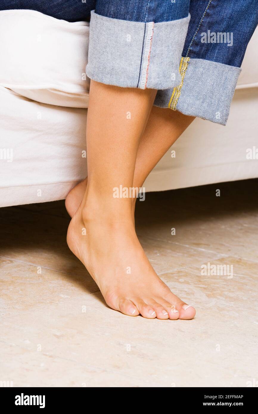 Low section view of a young woman sitting on a couch Stock Photo - Alamy