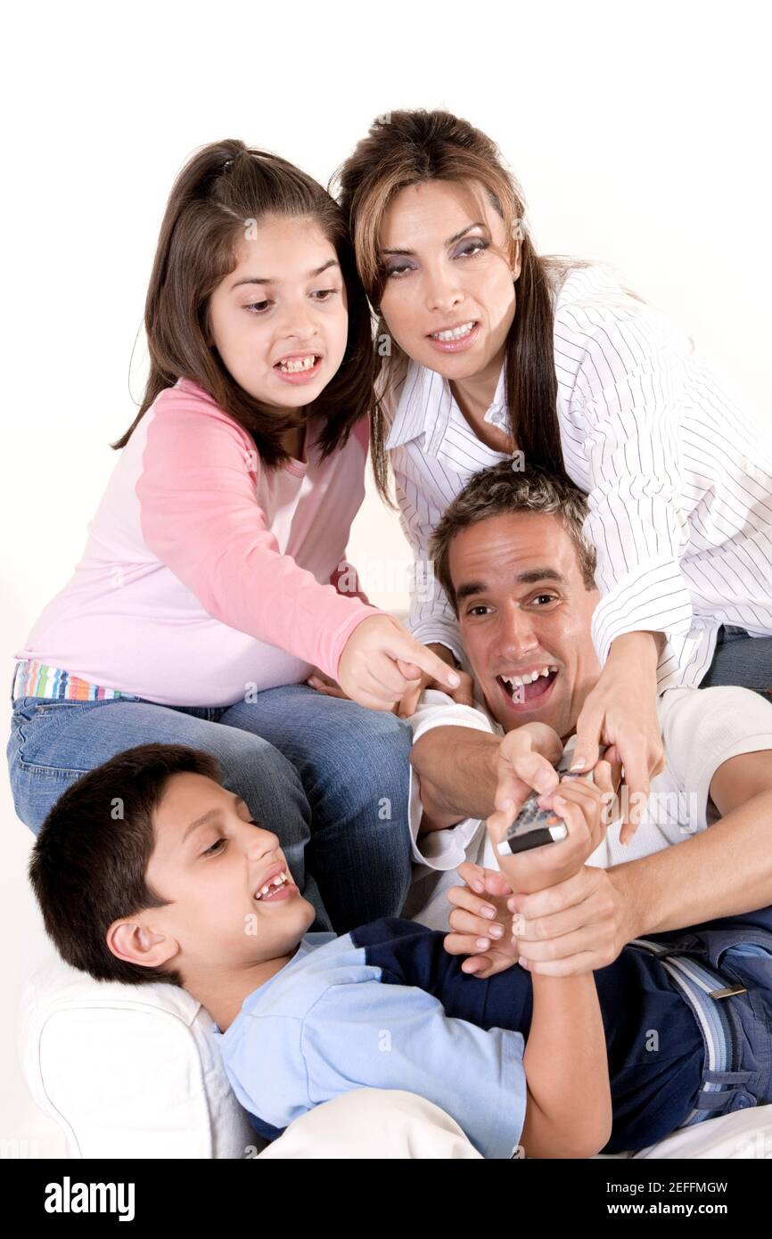 Parents with their son and daughter pressing buttons on a remote ...
