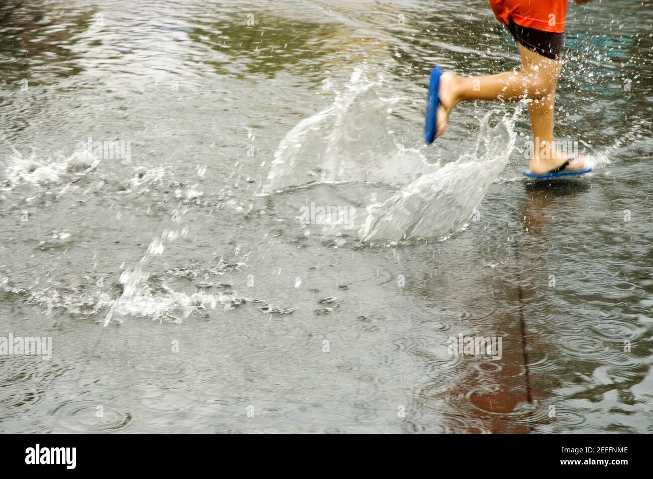 Low section view of a boy splashing water Stock Photo - Alamy