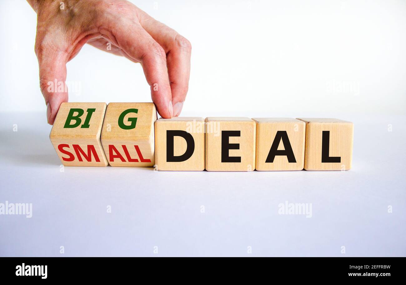 Big or small deal symbol. Businessman turns a wooden cube and changes ...