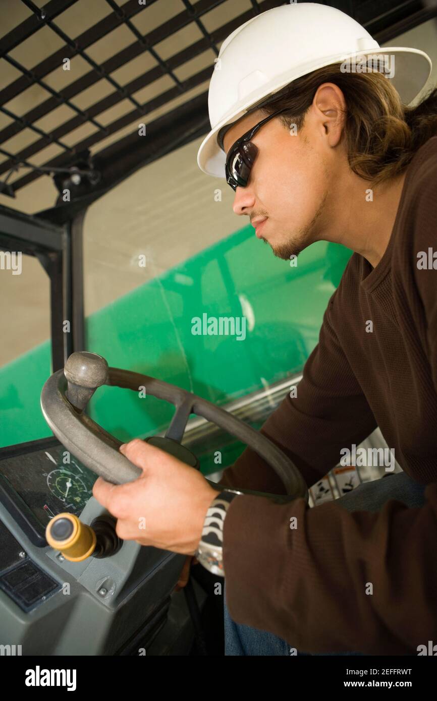 Side profile of a male construction worker operating a crane Stock ...