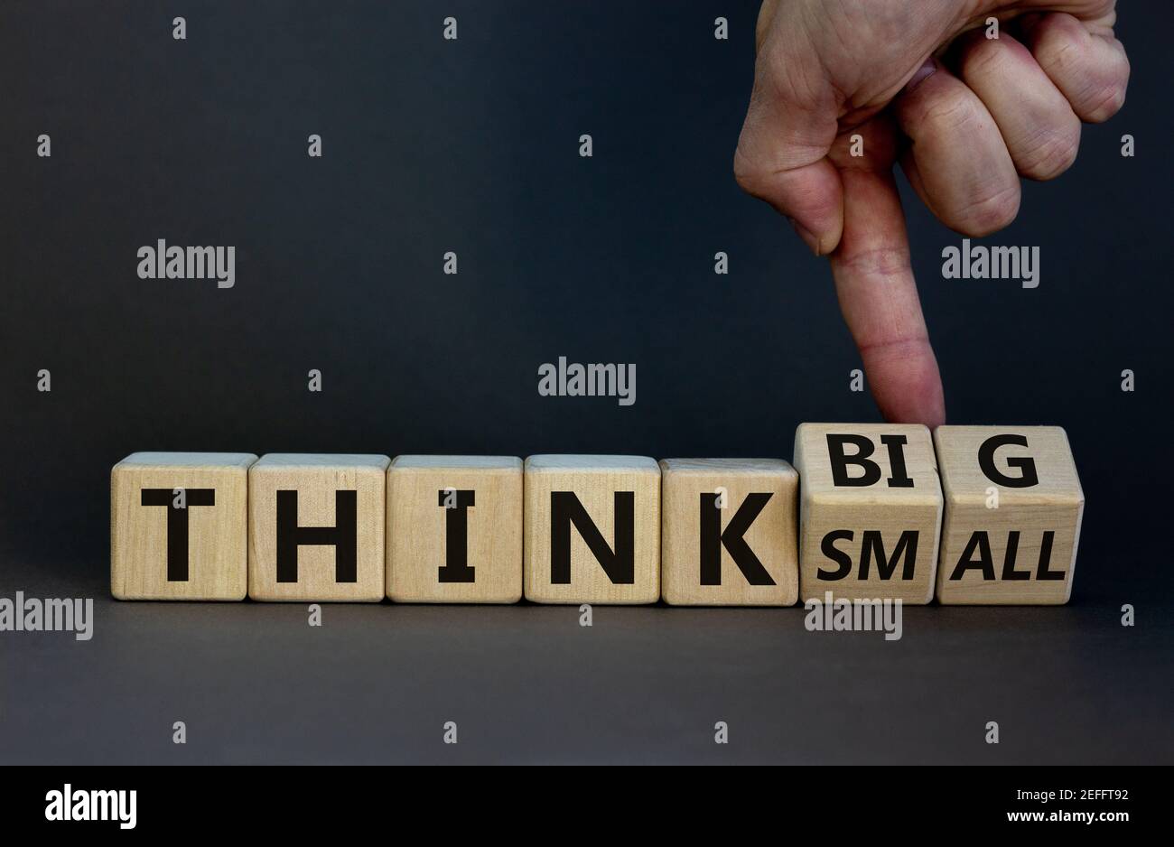 Think small or big concept. Businessman turns wooden cubes, changes ...