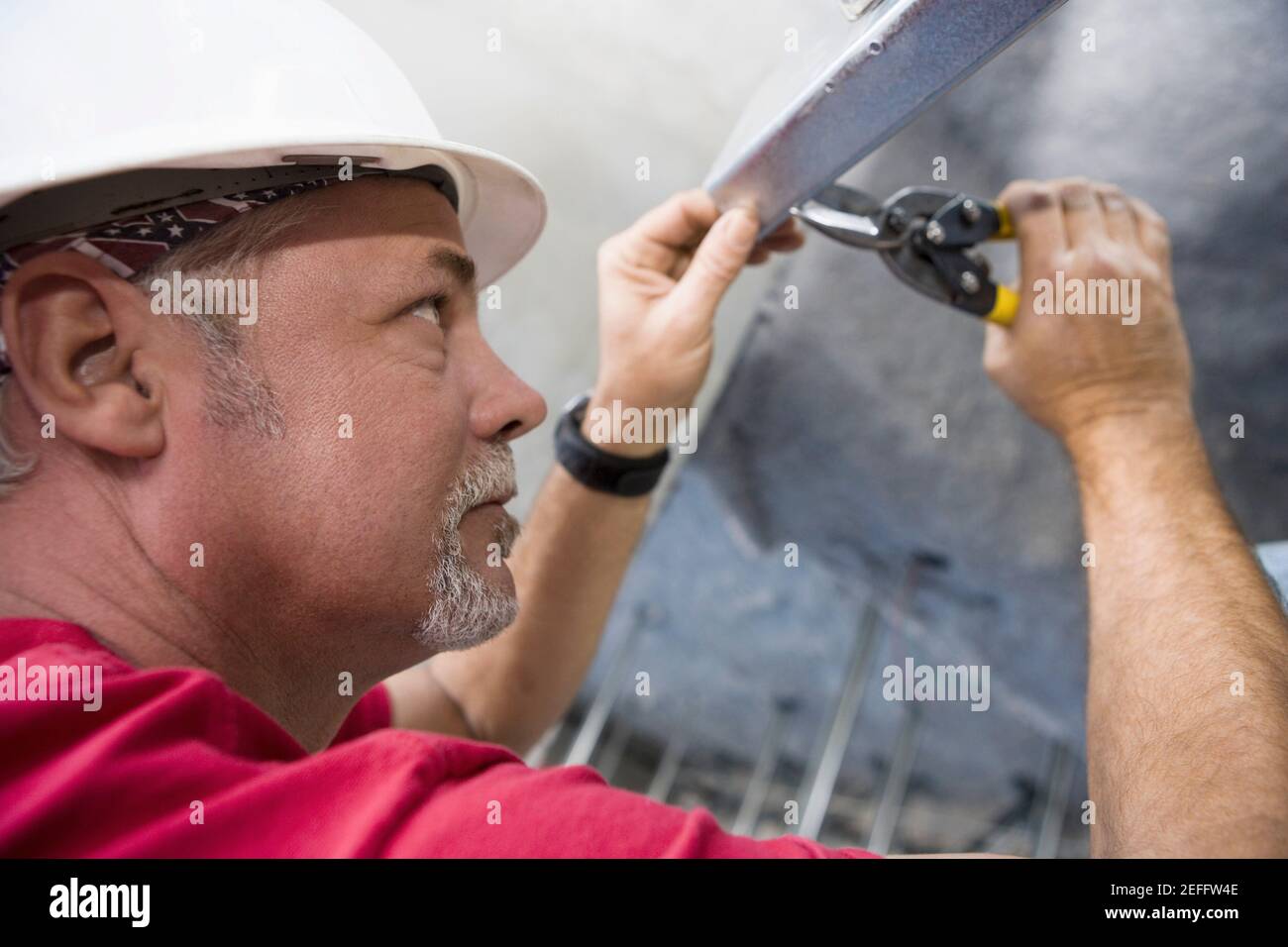 Side profile of a male construction worker working with a wrench Stock ...