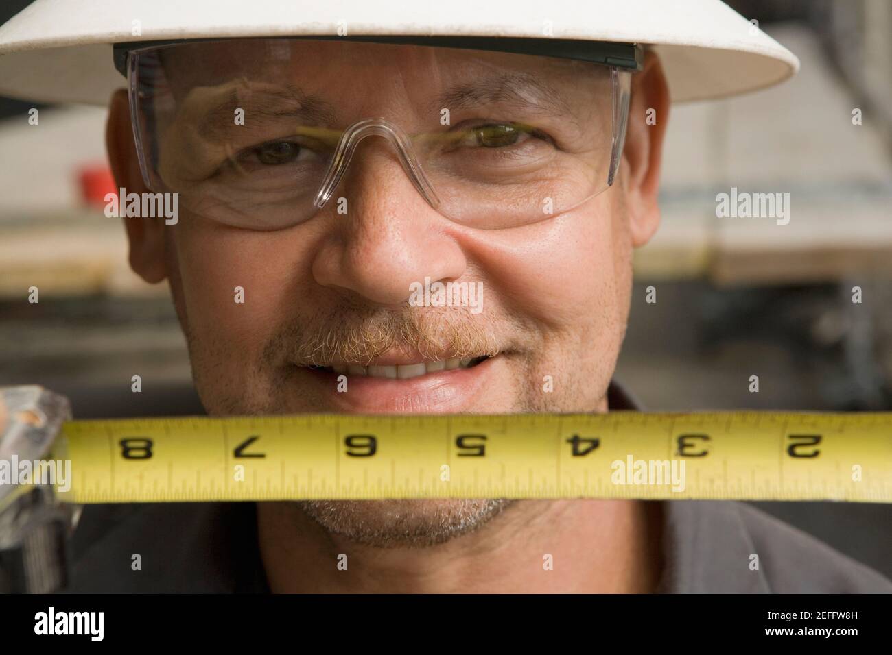 Construction worker is holding a tape measure hi-res stock photography ...