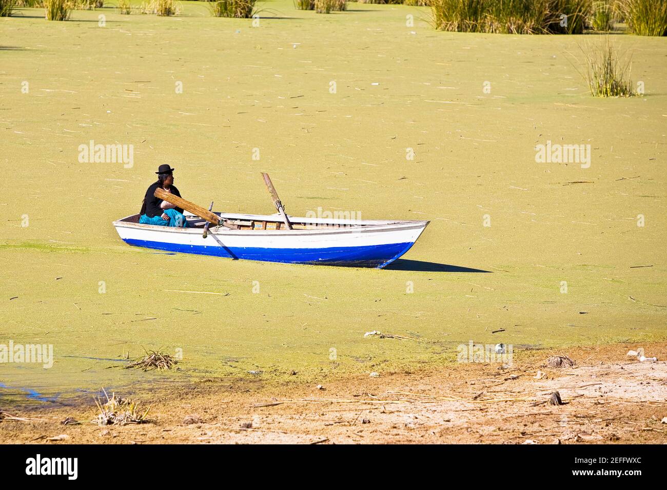 Side profile of a man sitting on a boat, Lake Titicaca, Puno, Peru ...