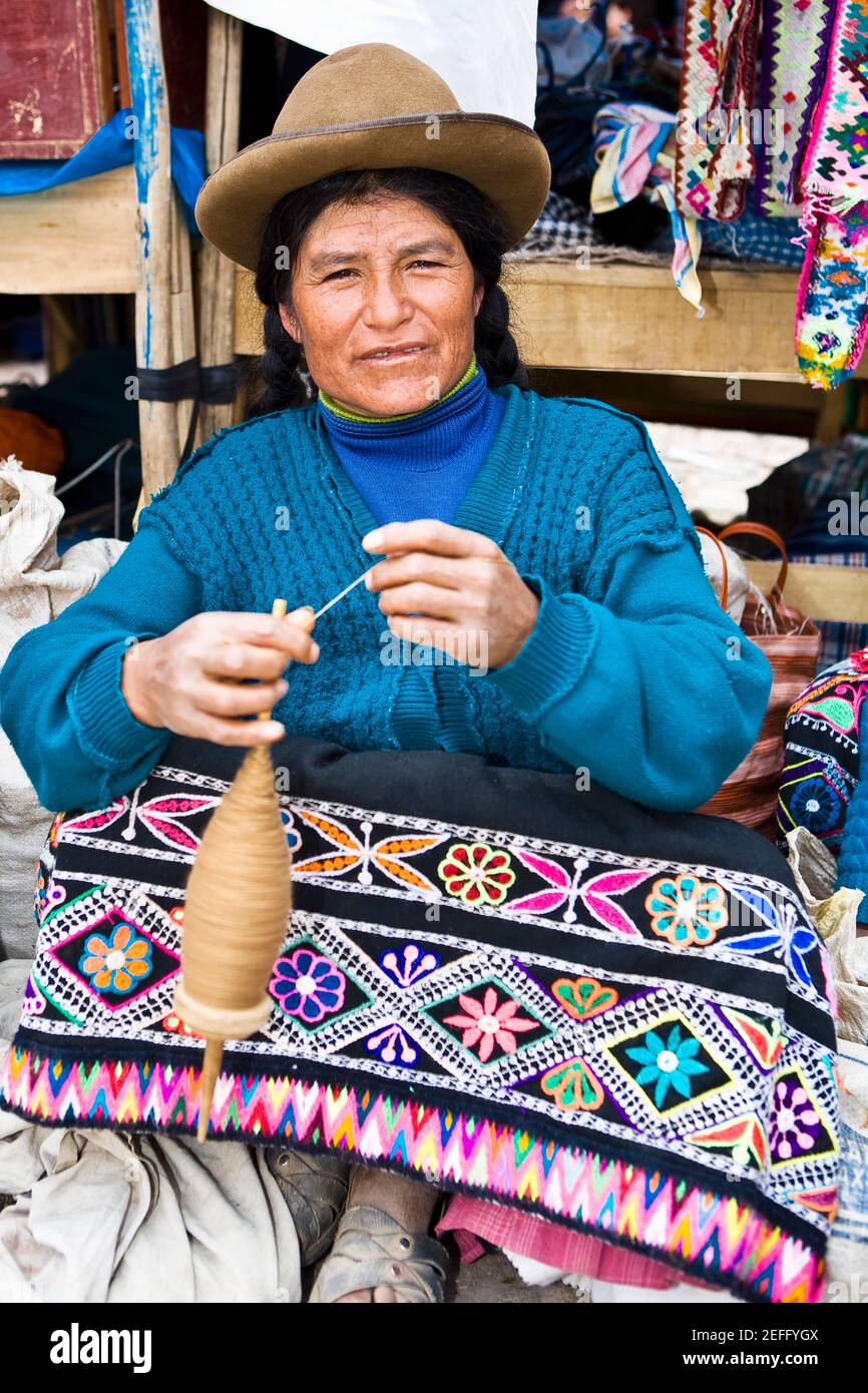 Portrait of a mature woman spinning a spool, Peru Stock Photo - Alamy