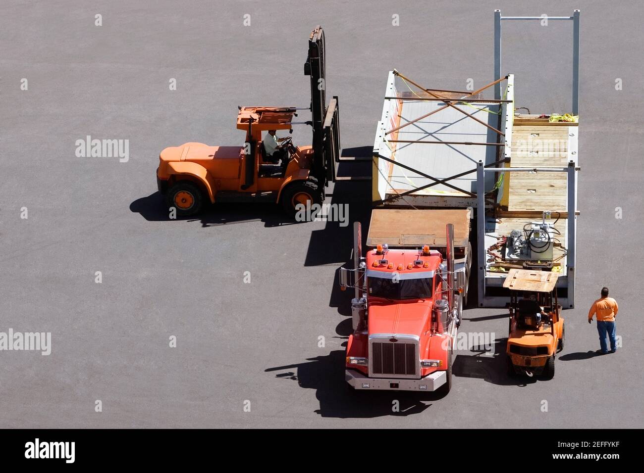 High angle view of a semi-truck and forklifts at a commercial dock ...