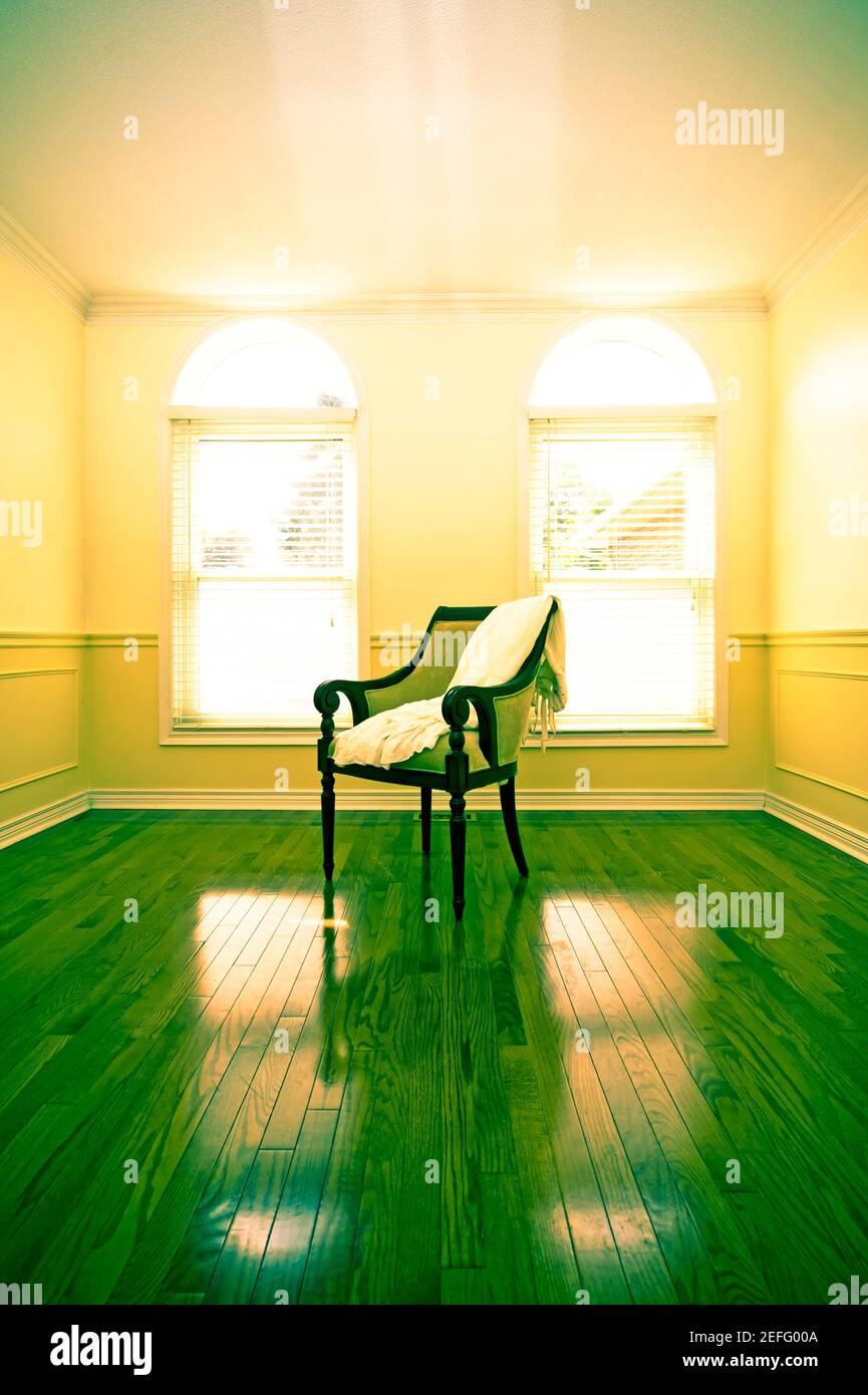white dress on a chair in an empty room Stock Photo - Alamy