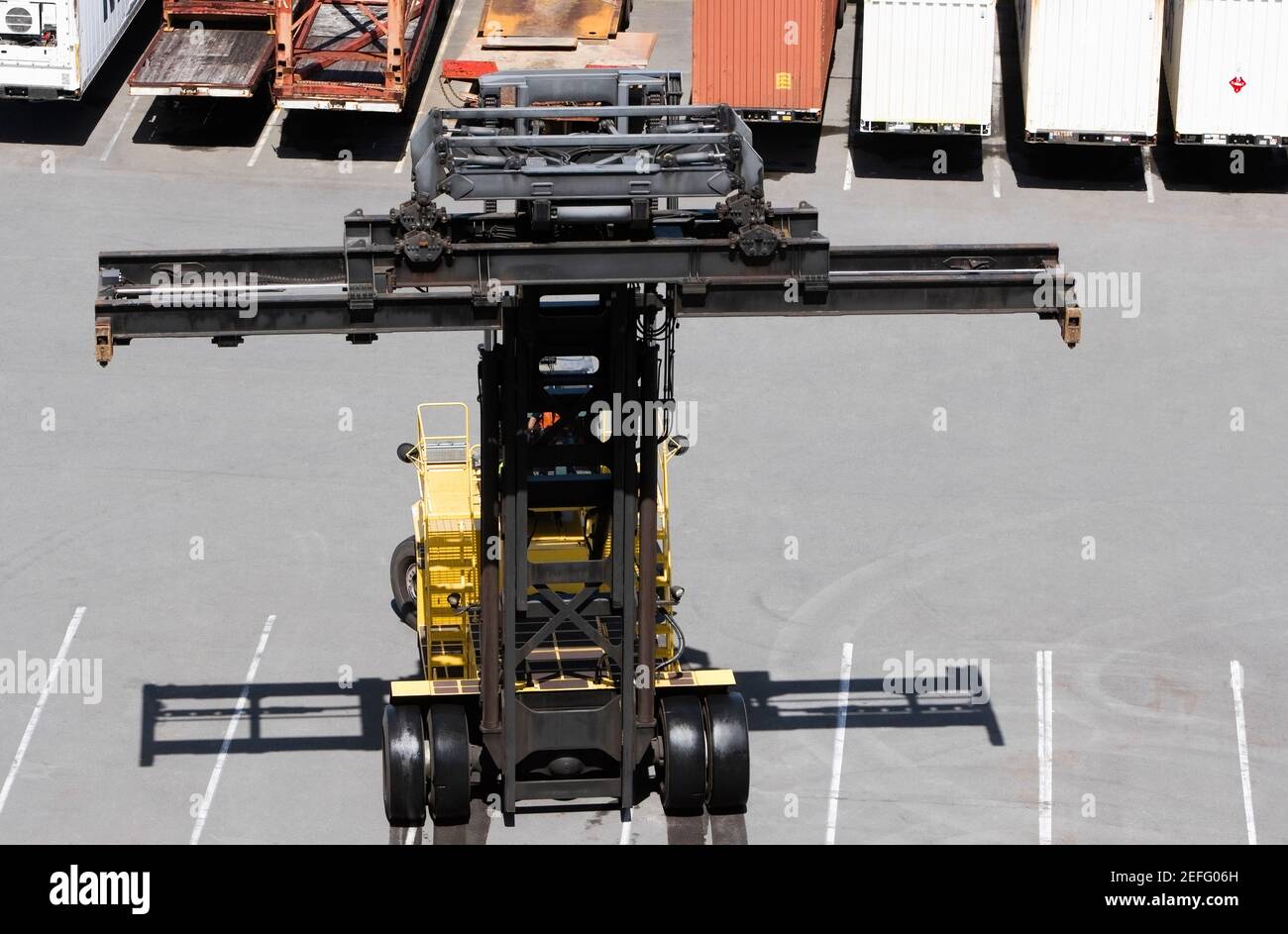 High angle view of a forklift with cargo containers in the background ...