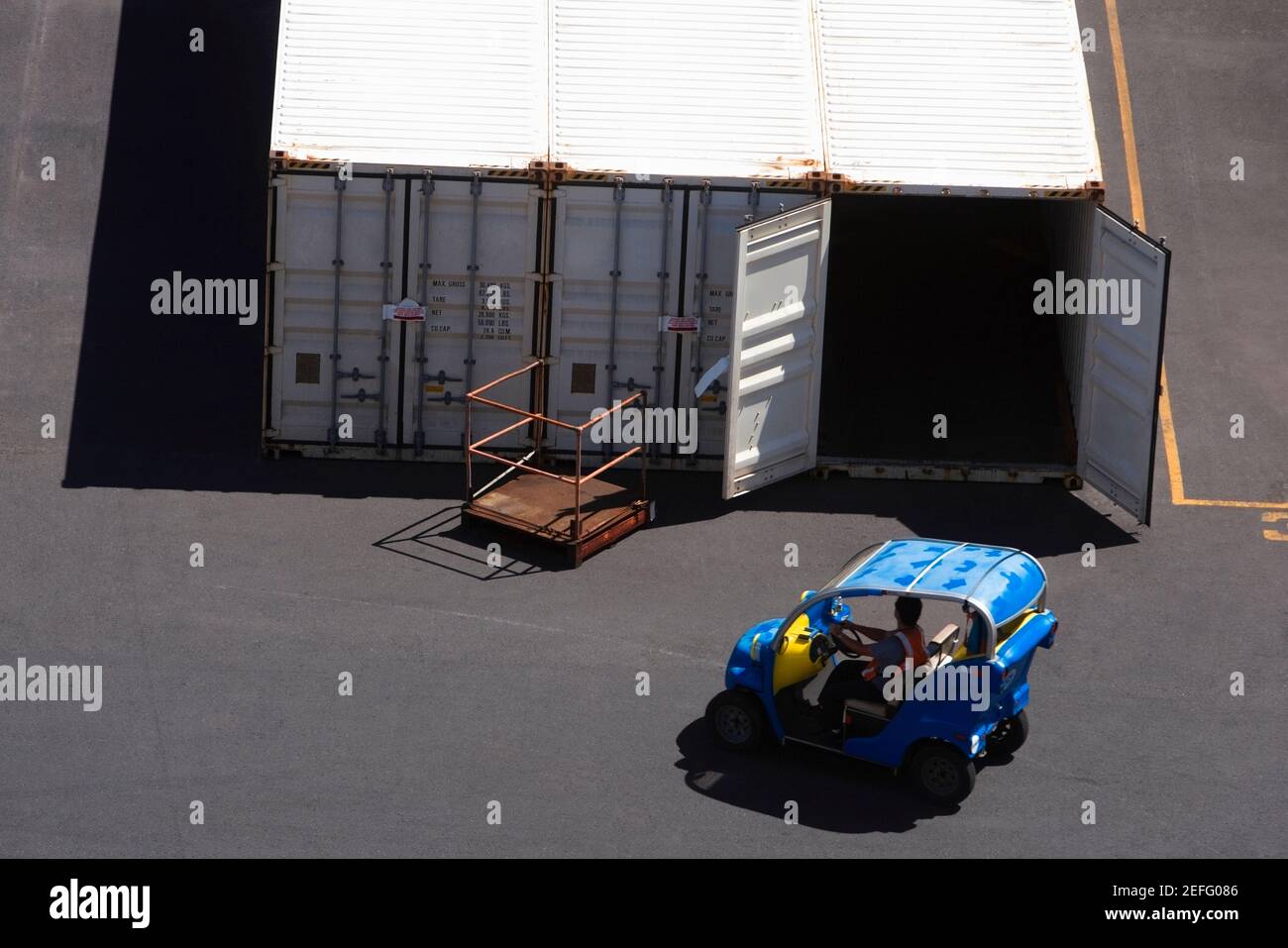 High angle view of a car in front of cargo containers at a commercial ...