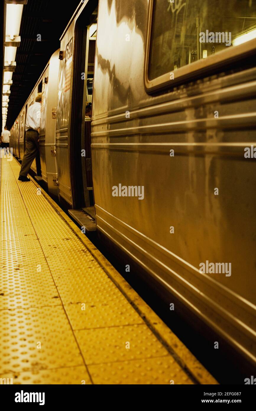 Train at a railroad station platform Stock Photo - Alamy