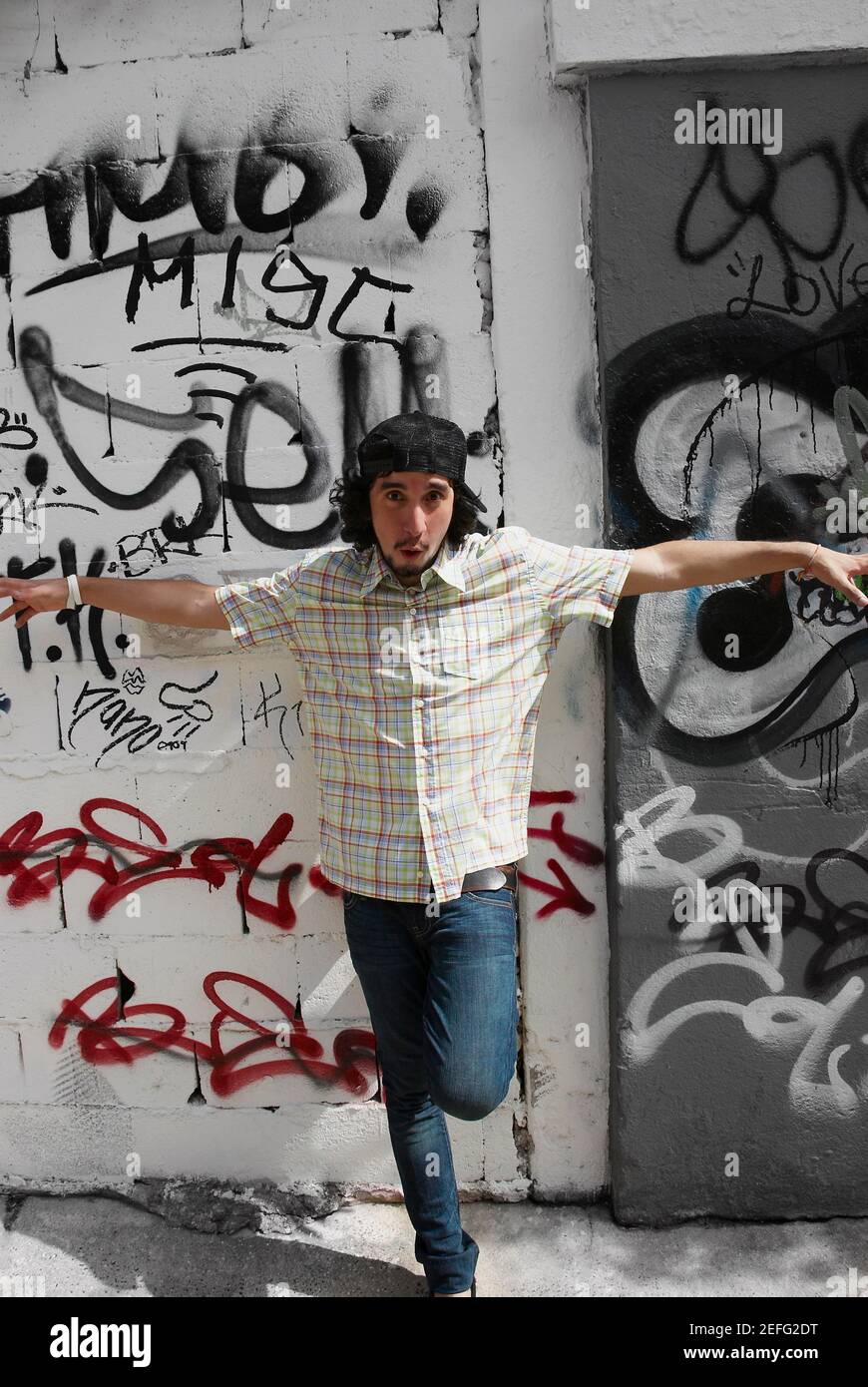 Portrait of a young man posing in front of a wall Stock Photo - Alamy