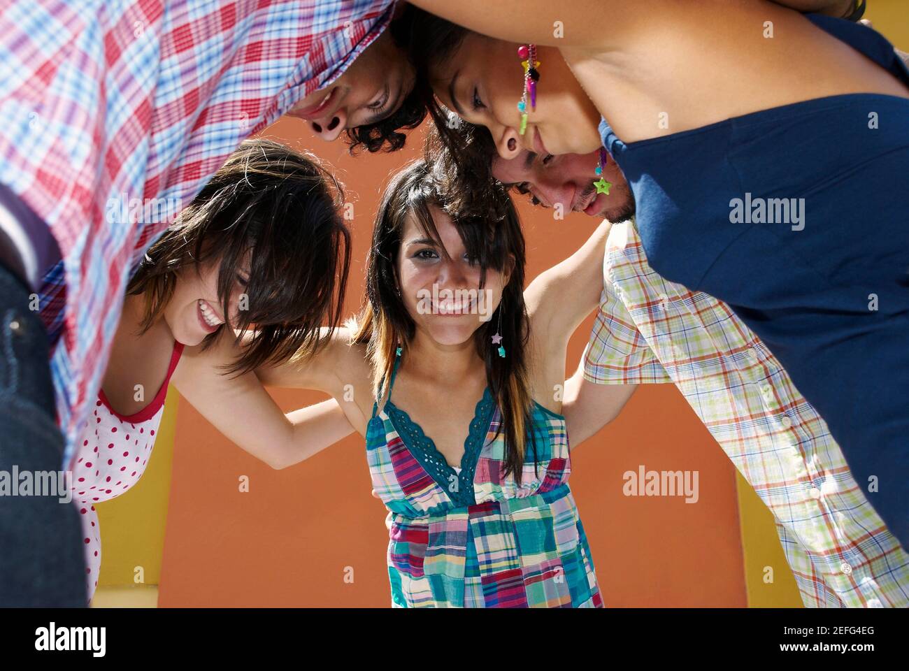 Low angle view of five friends standing in a huddle and smiling Stock ...