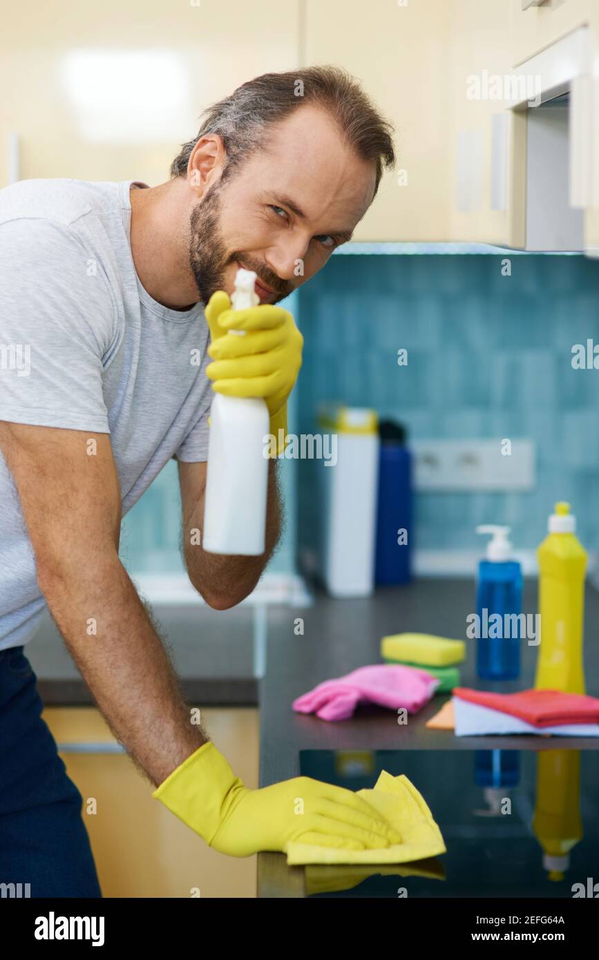 Portrait of professional male cleaner wearing gloves looking at camera ...