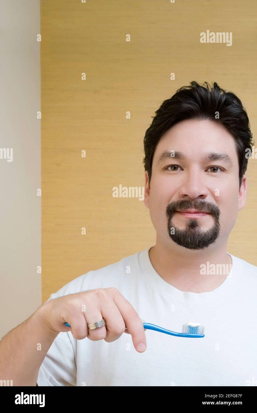 Portrait of a mid adult man holding a toothbrush Stock Photo - Alamy