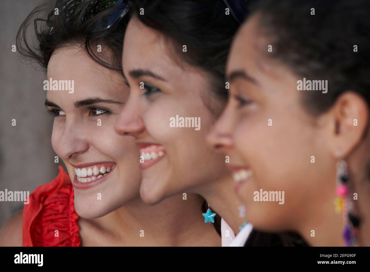Side profile of three young women smiling Stock Photo - Alamy