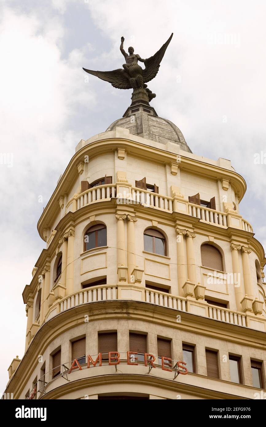 Low angle view of an angel statue on the top of a building, Madrid ...