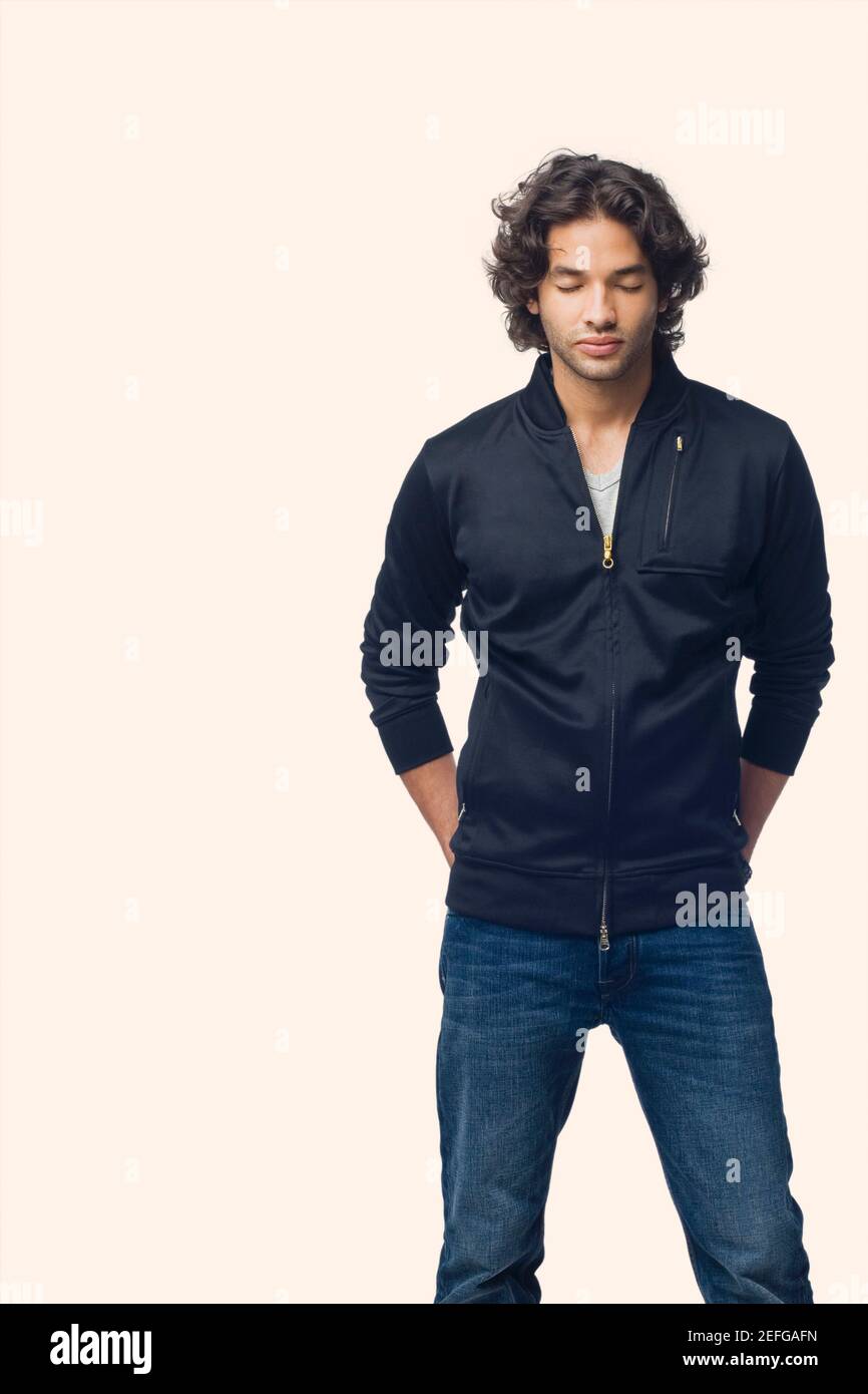 Young man standing with his hands in his pockets hi-res stock ...