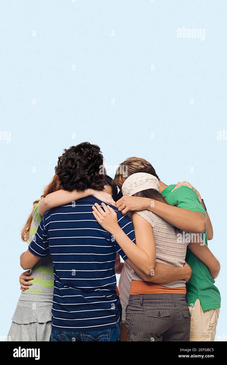 Two men and three young women making a huddle Stock Photo - Alamy
