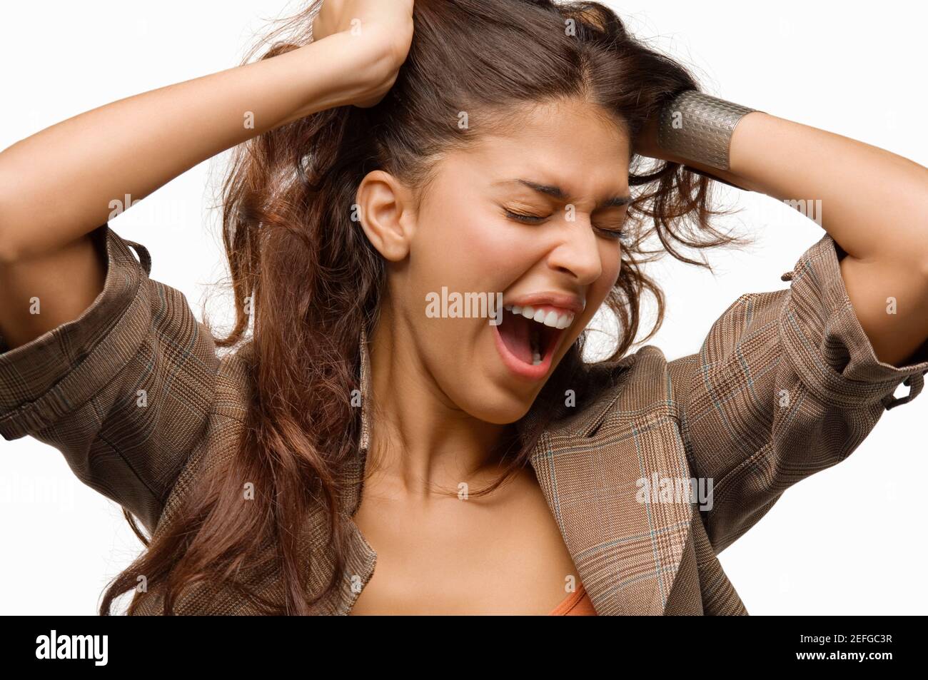 Close-up of a young woman screaming with her hands in her hair Stock ...