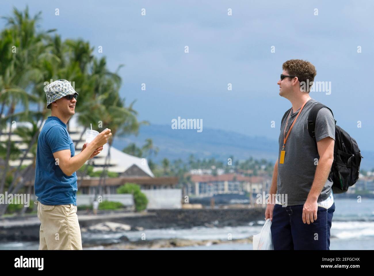 Two young men standing on the beach, Kona, Big Island, Hawaii Islands ...