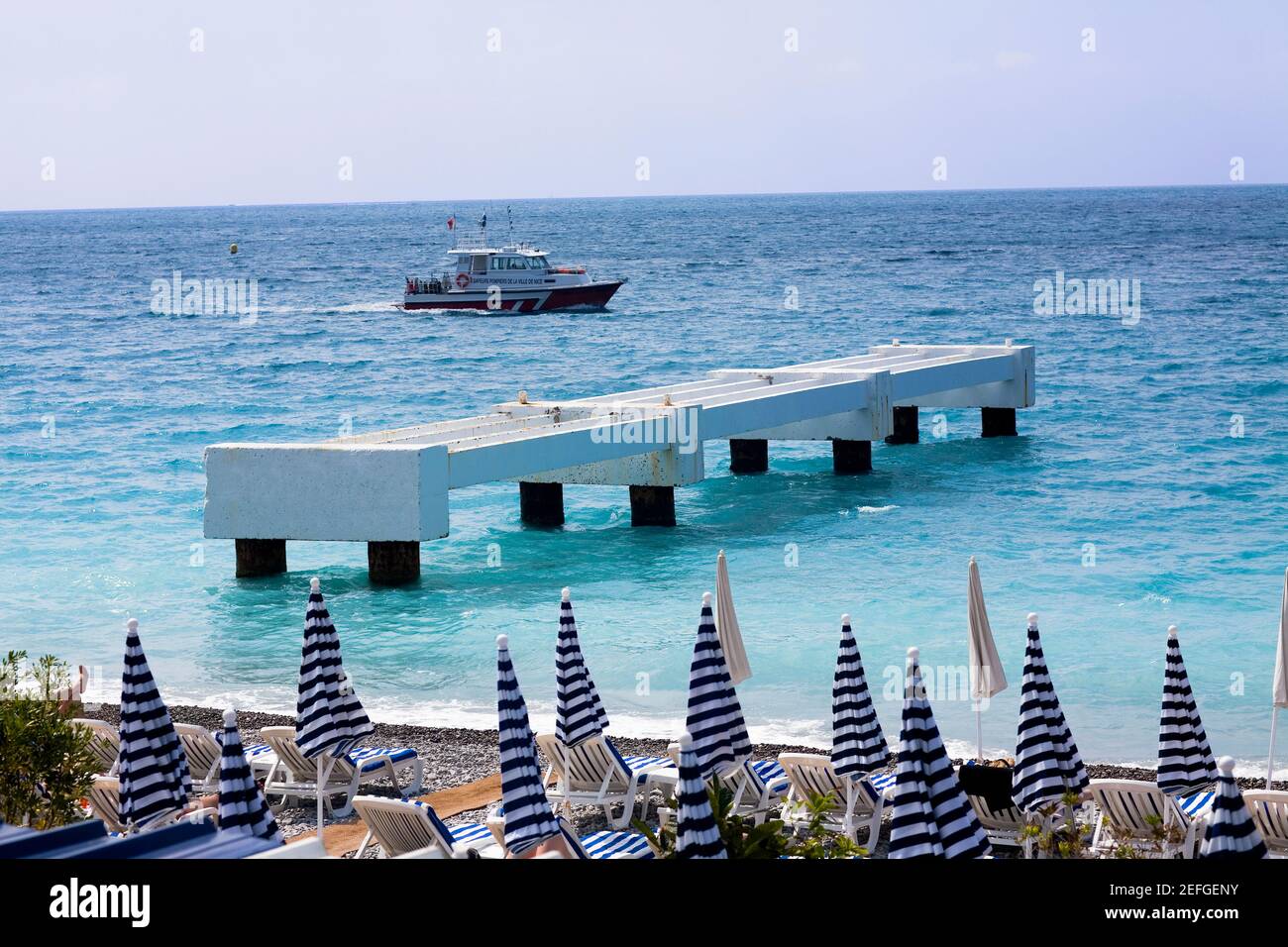 Jetty in the sea with a passenger ship in the background, Nice, France ...