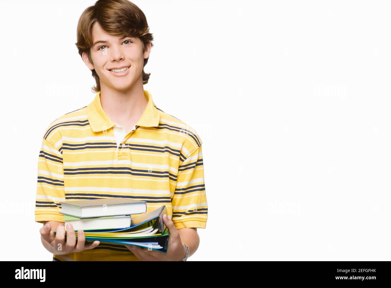 Portrait of a teenage boy holding books and ring binders Stock Photo ...