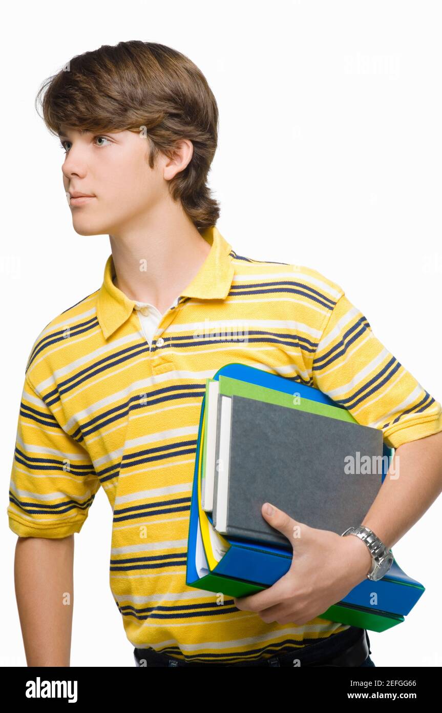 Close-up of a teenage boy carrying books and ring binders Stock Photo ...