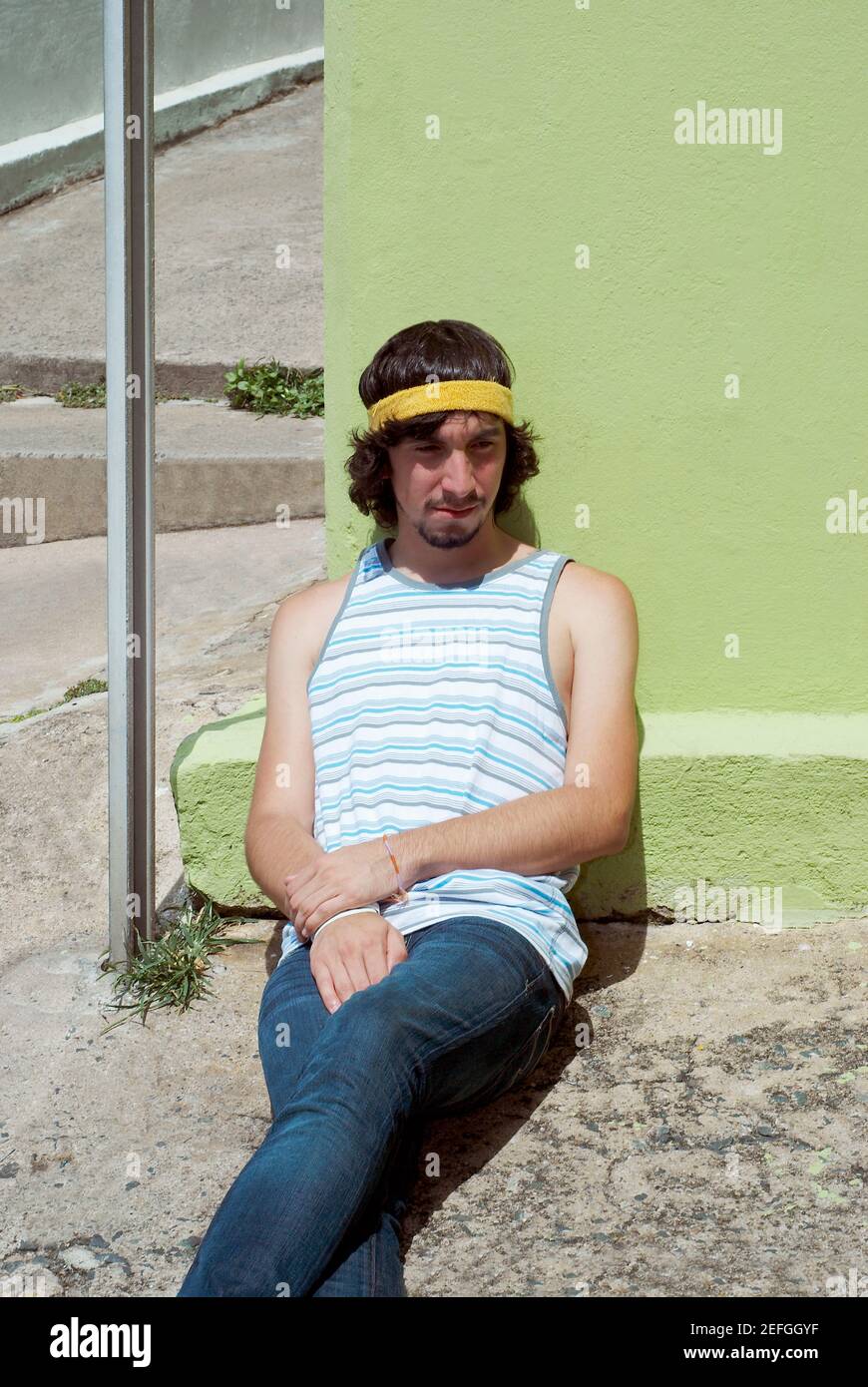 Young man leaning against a wall and thinking Stock Photo - Alamy