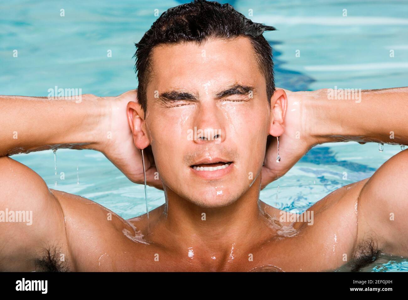 Close-up of a young man splashing water in a swimming pool Stock Photo ...