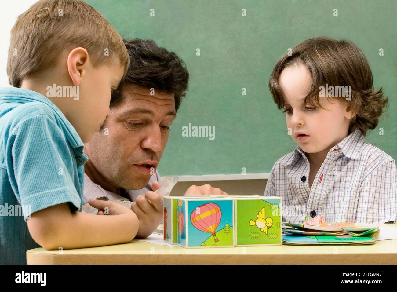 Male teacher teaching his students in a classroom Stock Photo - Alamy