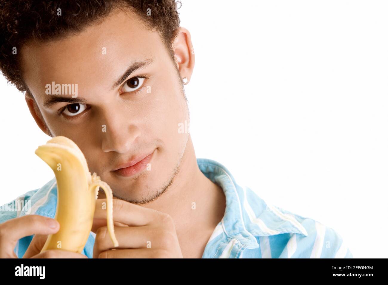 Portrait of a young man peeling a banana Stock Photo - Alamy