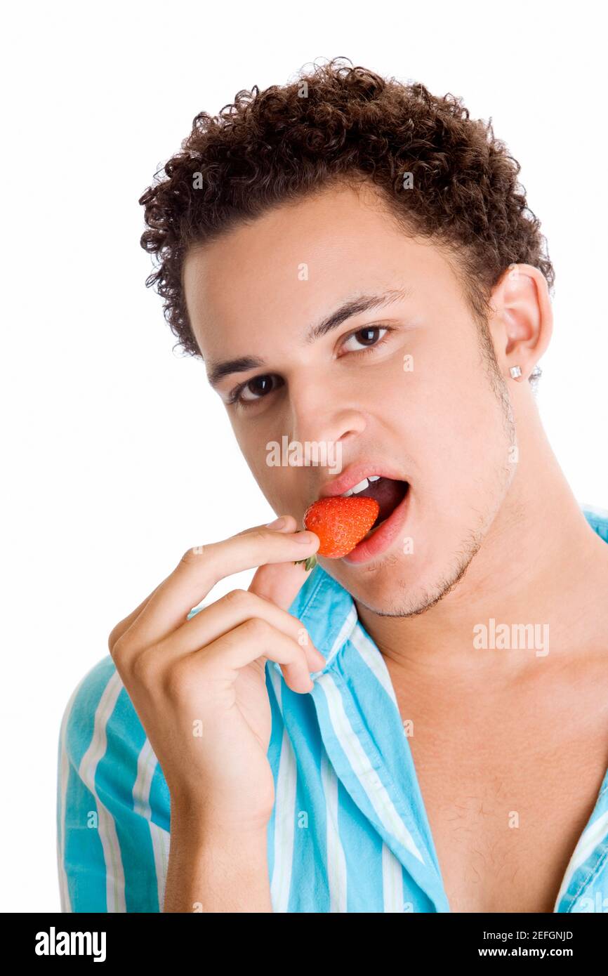 Man eating strawberry looking camera hi-res stock photography and ...