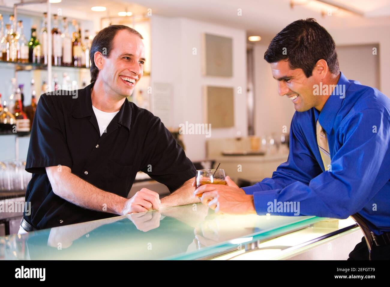 Side profile of a businessman and a bartender at a bar counter Stock ...
